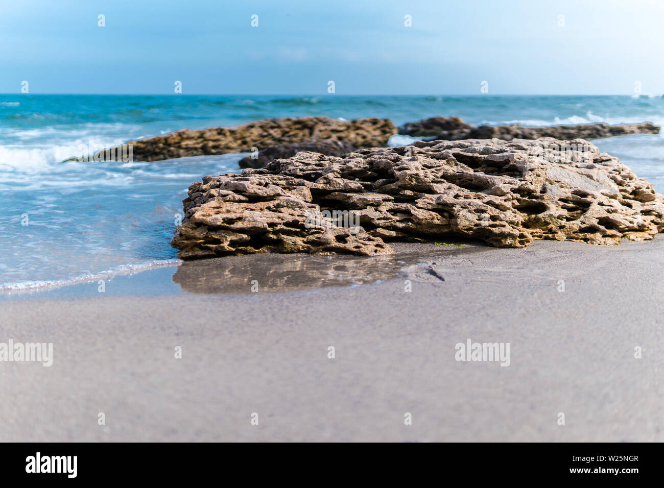 Soft wave crashing stone at bay. Stones by the sea. Sea wave breaks on ...