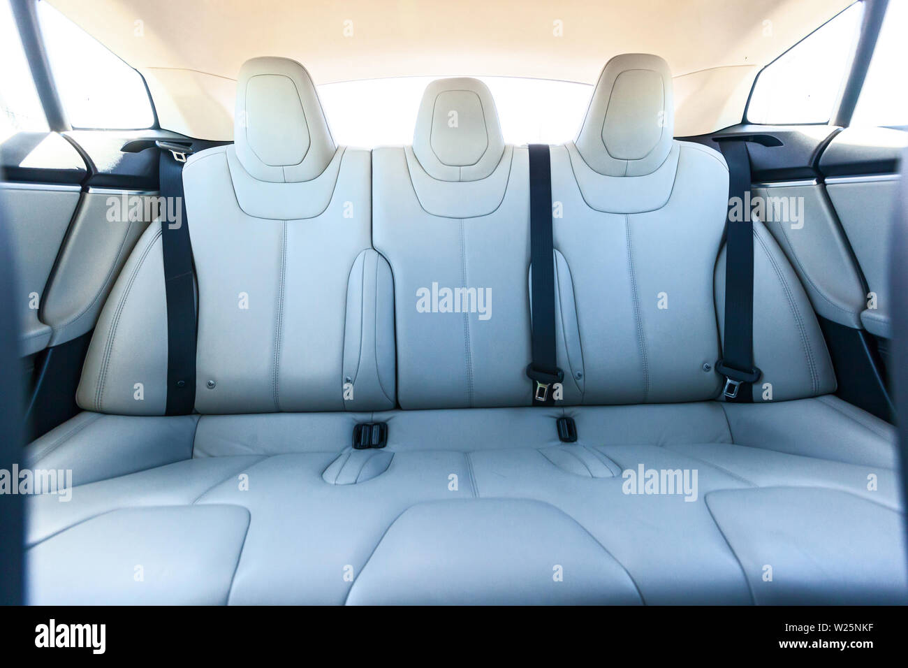 Back passenger seats in modern luxury car, frontal view, white leather ...