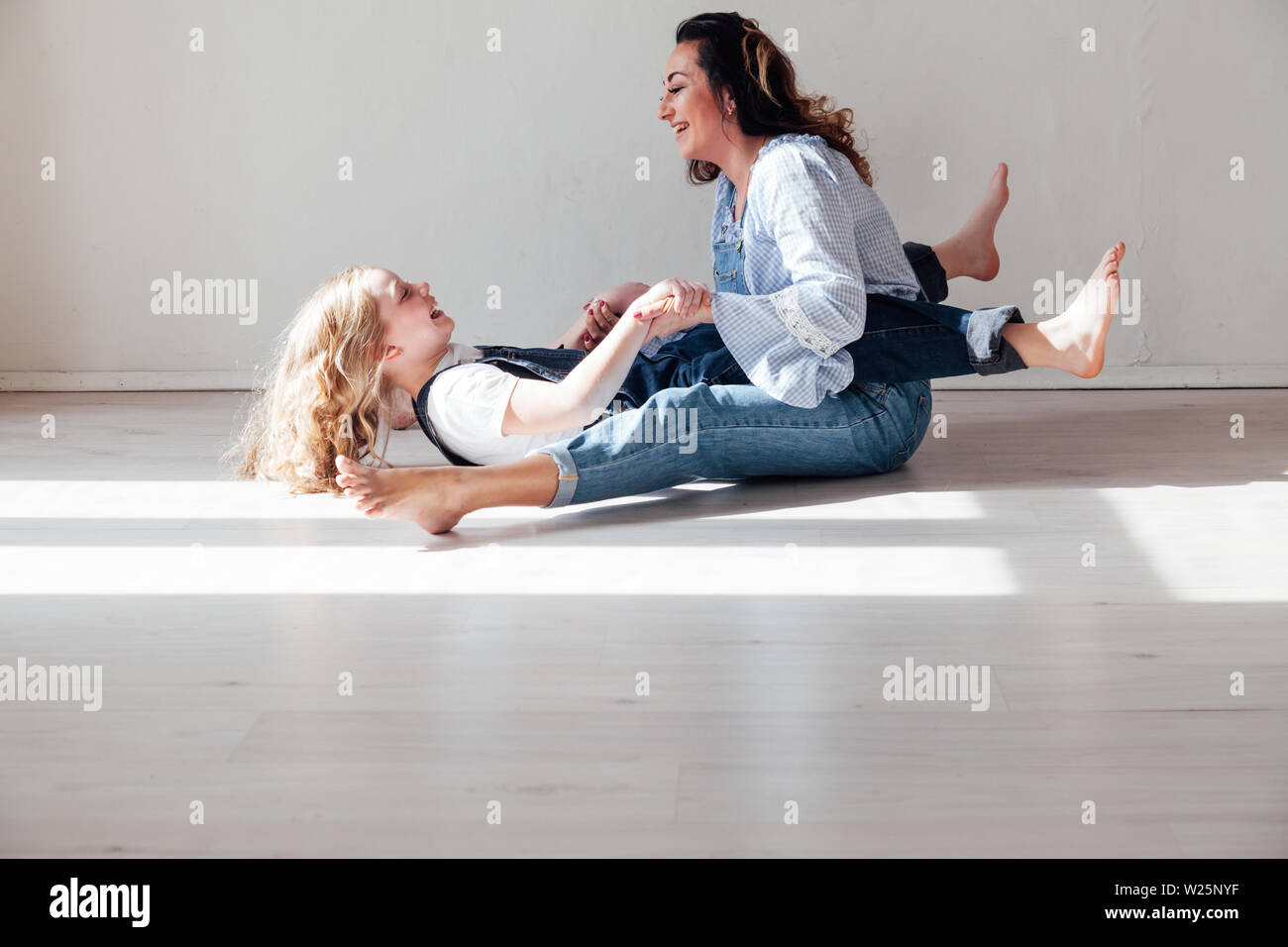 Mom and daughter play cuddles at home on the floor Stock Photo - Alamy