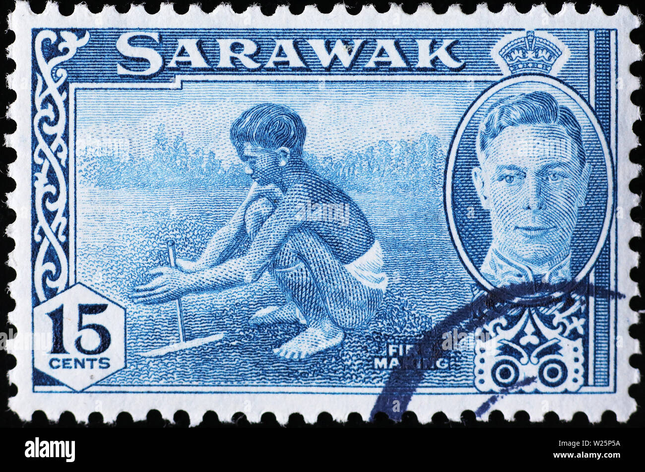 Native making fire on ancient stamp of Borneo Stock Photo - Alamy