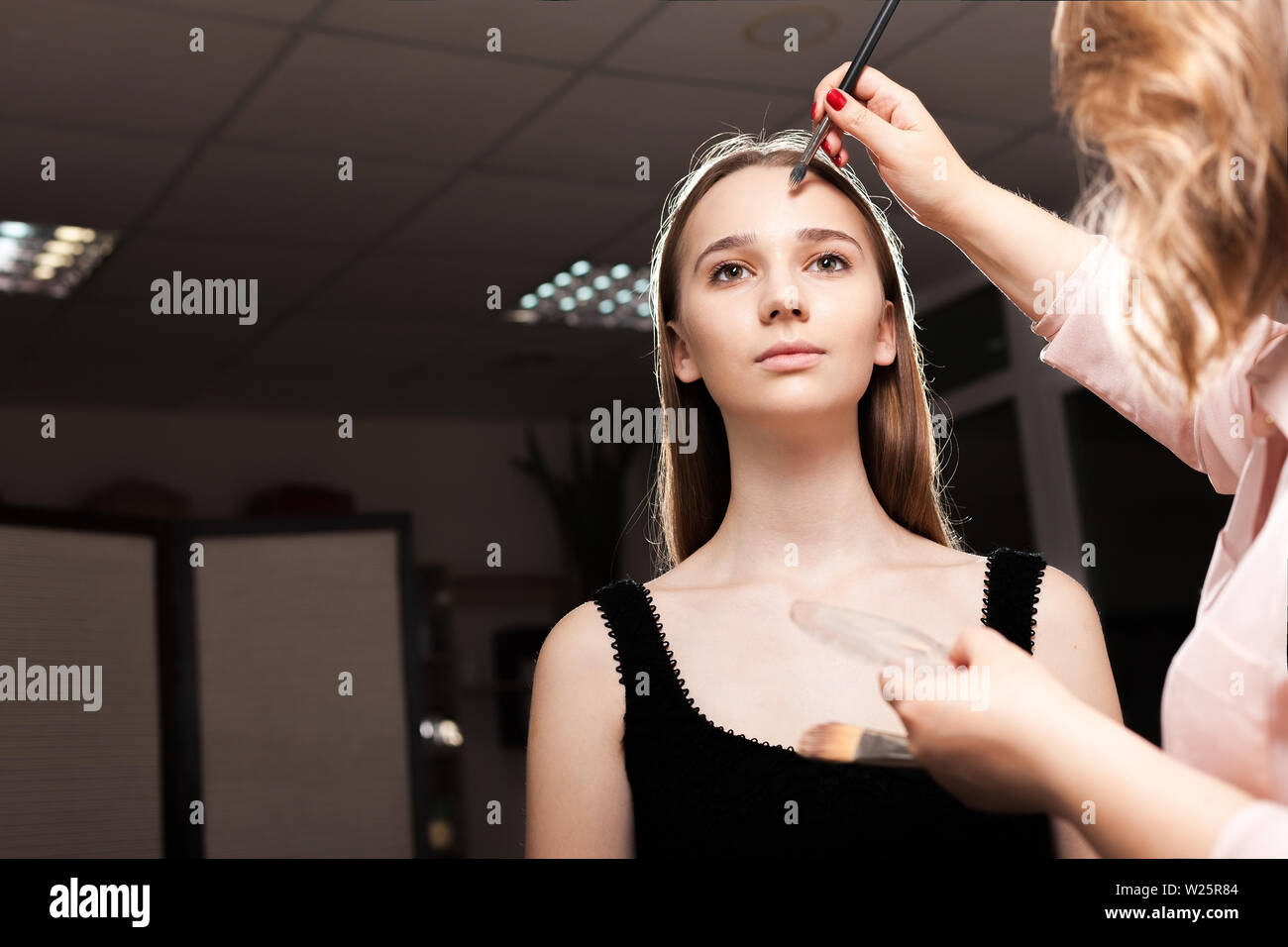 makeup artist dabbing foundation on a girl Stock Photo - Alamy