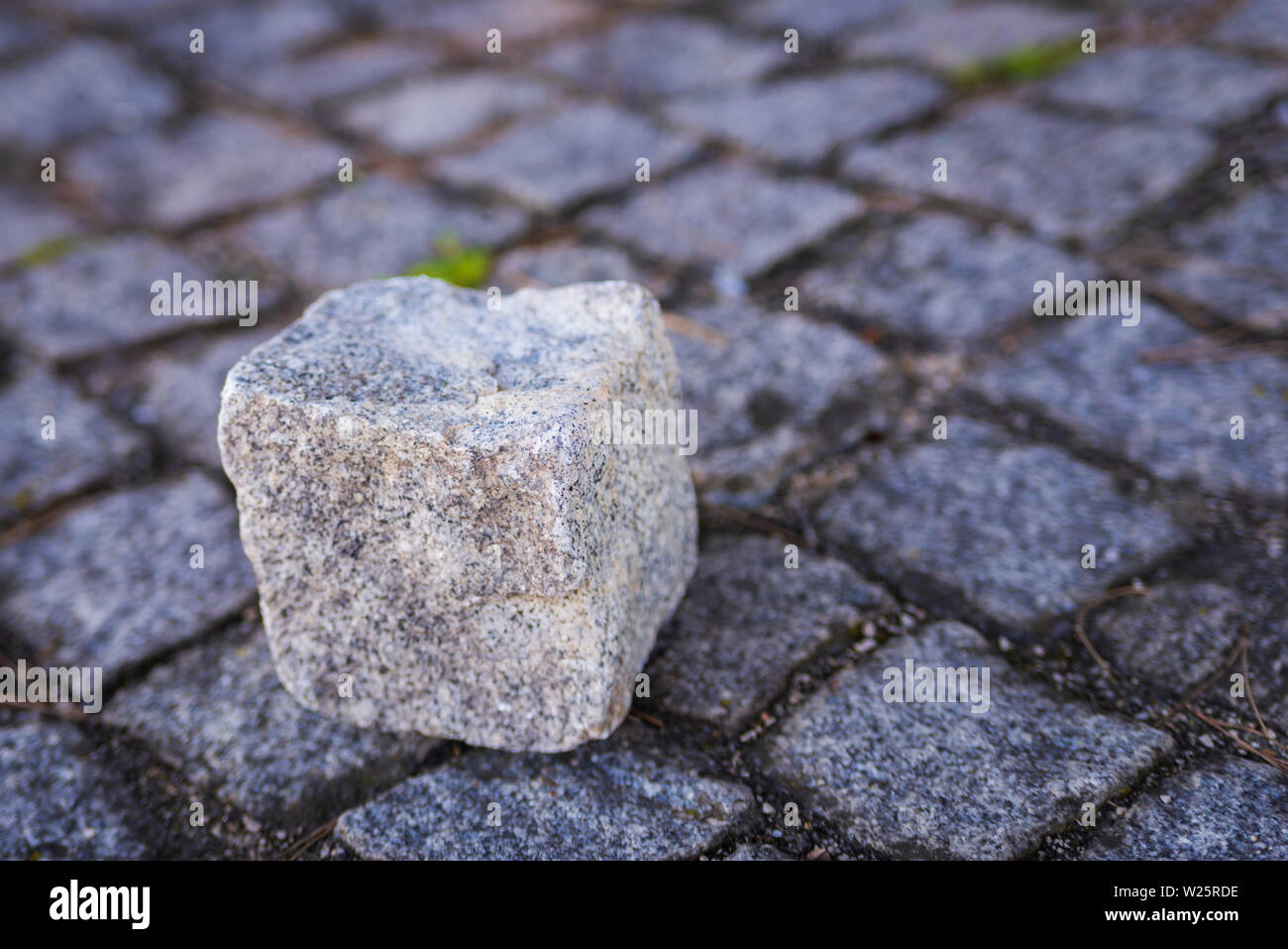 Stone cube on paving stone surface of walkway in Europe Stock Photo - Alamy