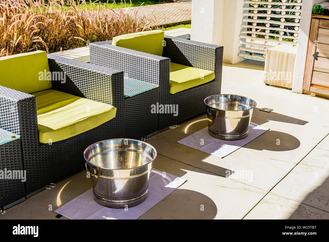 Metal buckets and seats at a foot spa at a luxury hotel Stock Photo - Alamy