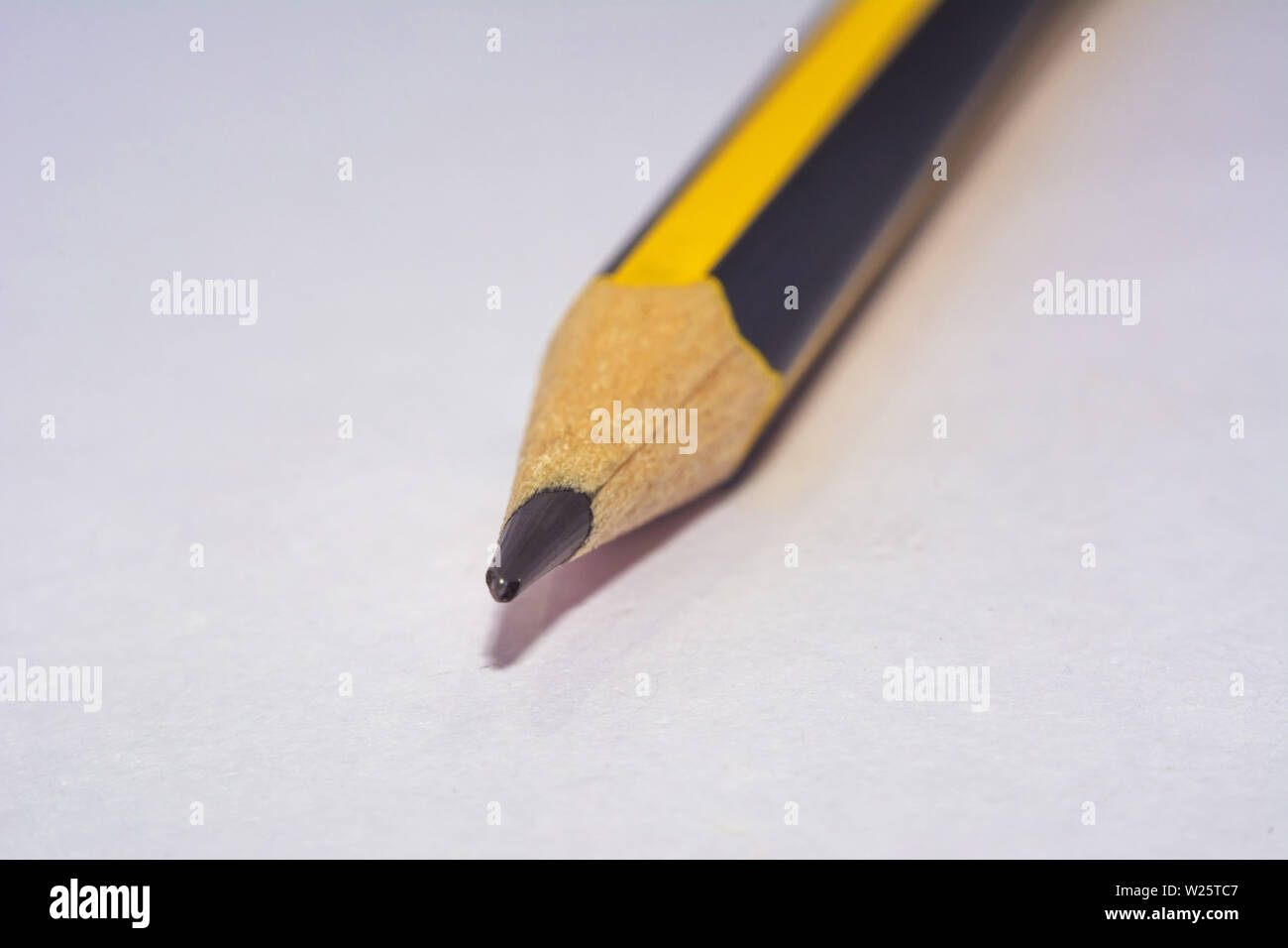 Yellow black colored pencil tip on white background Stock Photo - Alamy