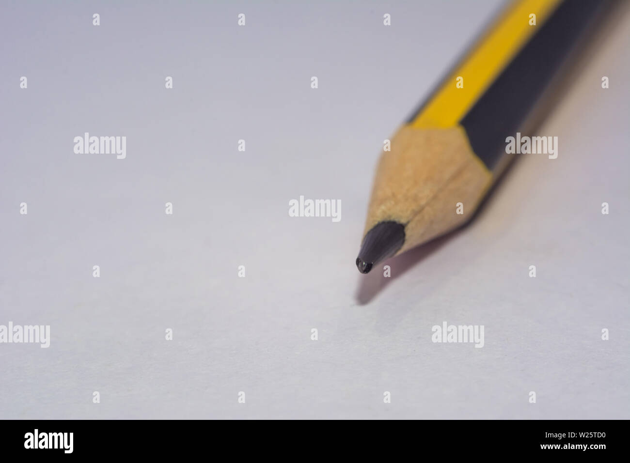 Yellow black colored pencil tip on white background Stock Photo - Alamy
