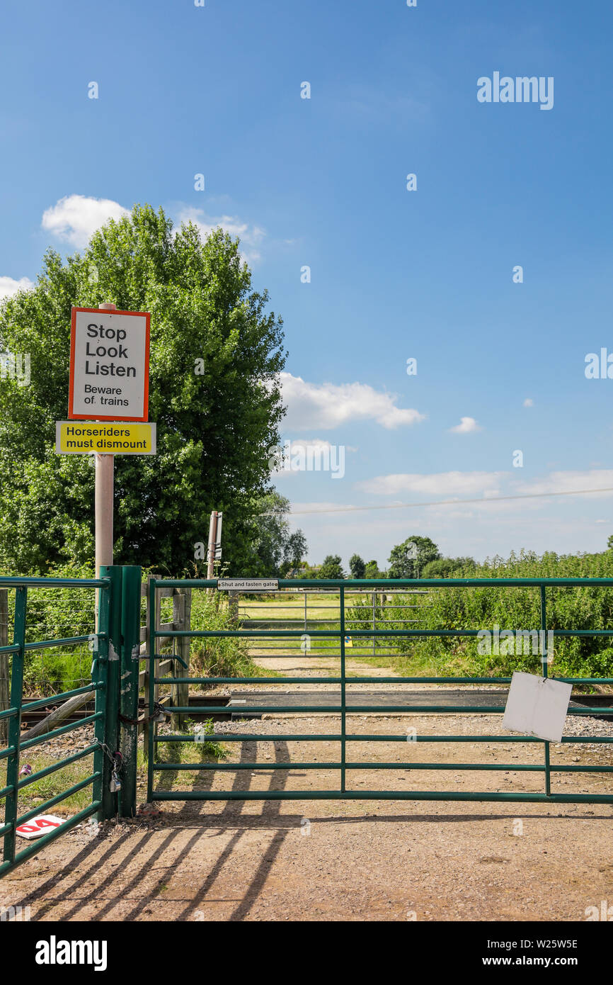 Warning signs at a self operated level crossing over railway track ...