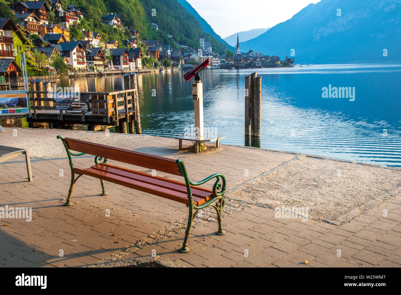Vintage bench by a mountain lake in an old Austrian town with beautiful ...