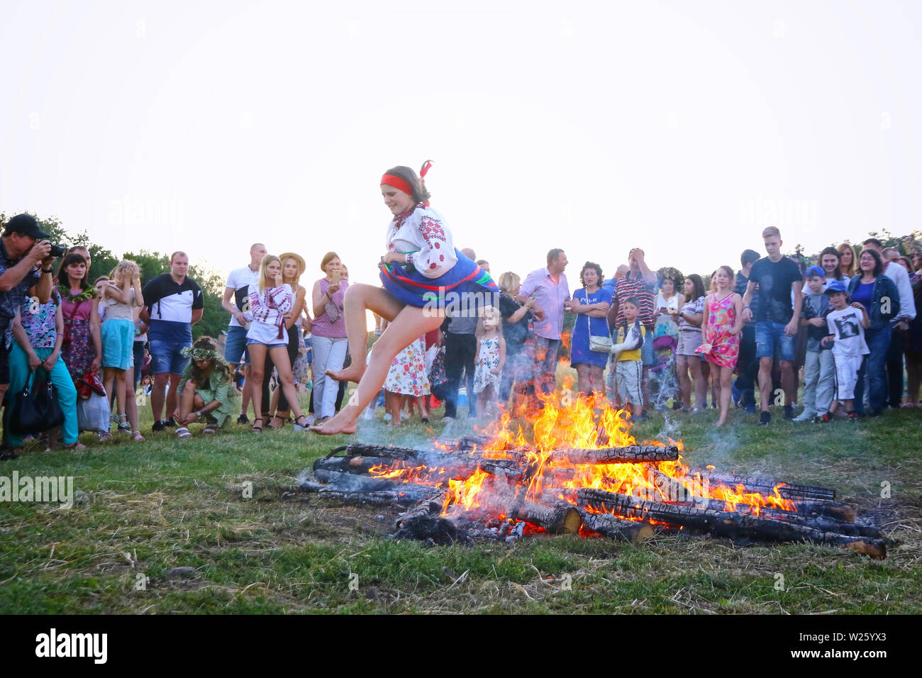 Kyiv, Ukraine - July 6, 2018: Young people jump over the flames of ...
