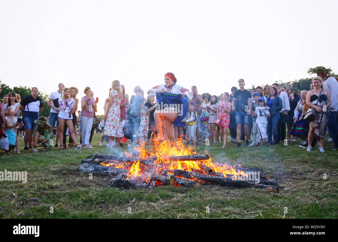Kyiv, Ukraine - July 6, 2018: Young people jump over the flames of ...