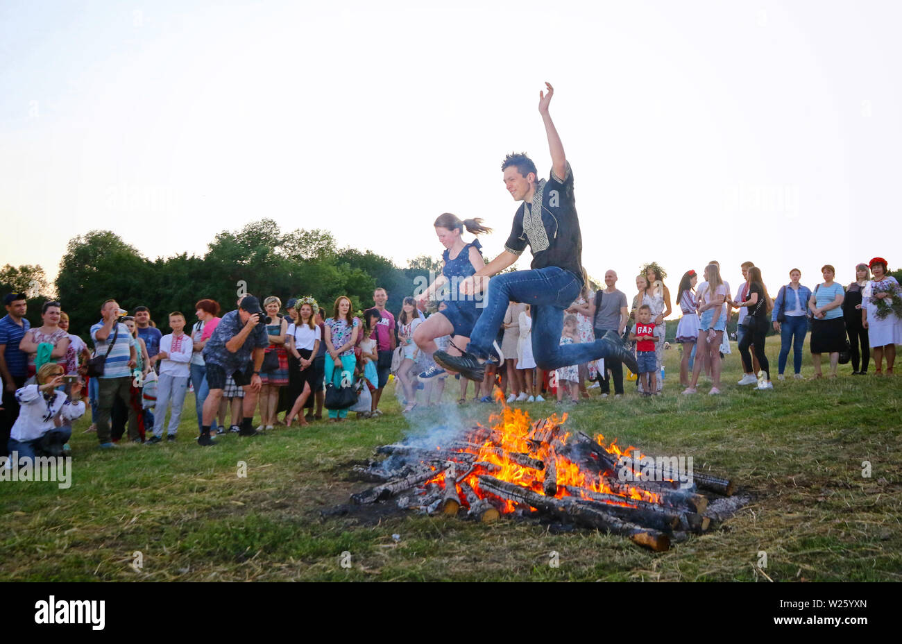 Kyiv, Ukraine - July 6, 2018: Young people jump over the flames of ...