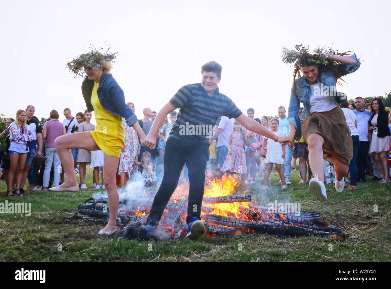 Kyiv, Ukraine - July 6, 2018: Young people jump over the flames of ...