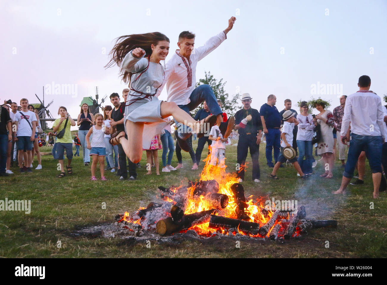 Kyiv, Ukraine - July 6, 2018: Young people jump over the flames of ...