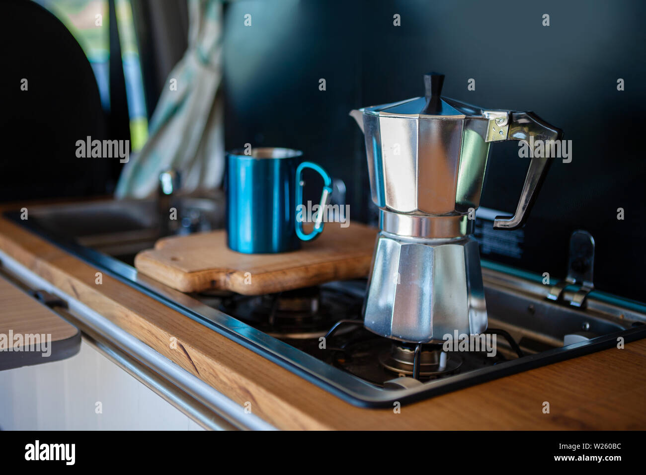 Aqua Bialetti stovetop coffee maker and mug, on a van gas cooker Stock ...