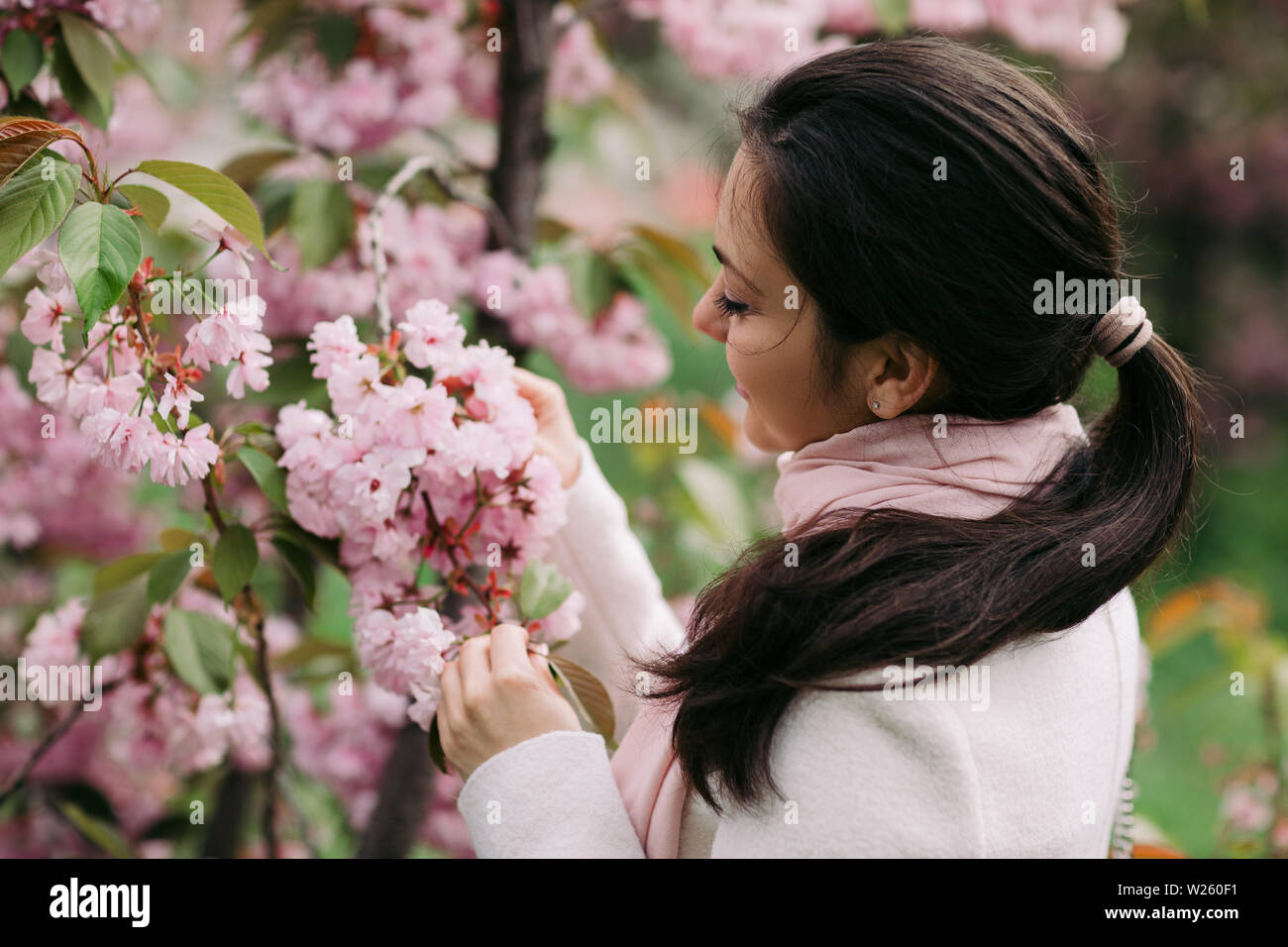 Beautiful young brunette woman enjoying spring day in park during ...