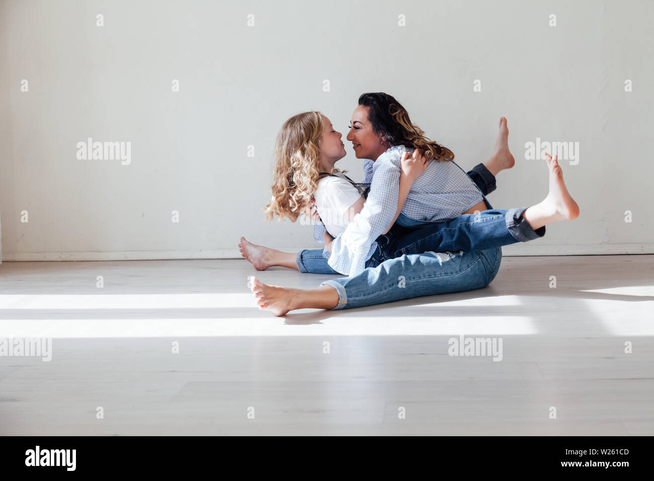 Mom and daughter play cuddles at home on the floor Stock Photo - Alamy