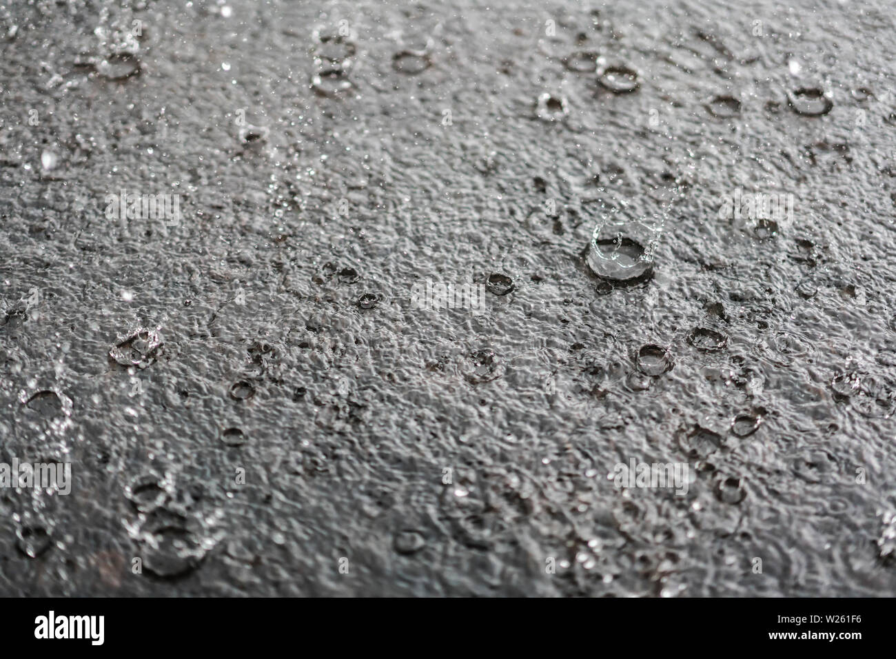 rain gray background. Drops on a puddle Stock Photo - Alamy