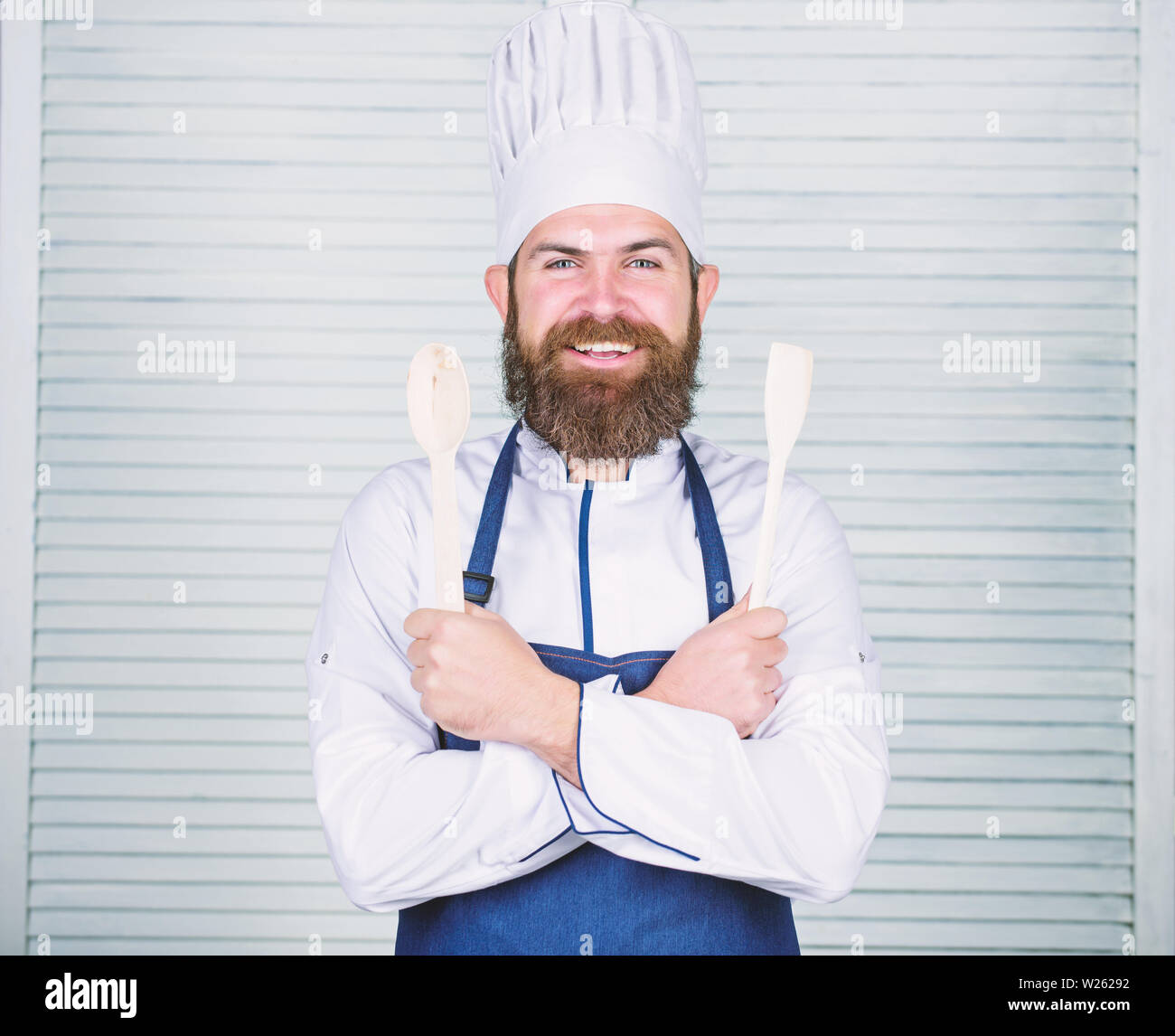 Add some spices. Man with beard in cook hat and apron hold cooking ...