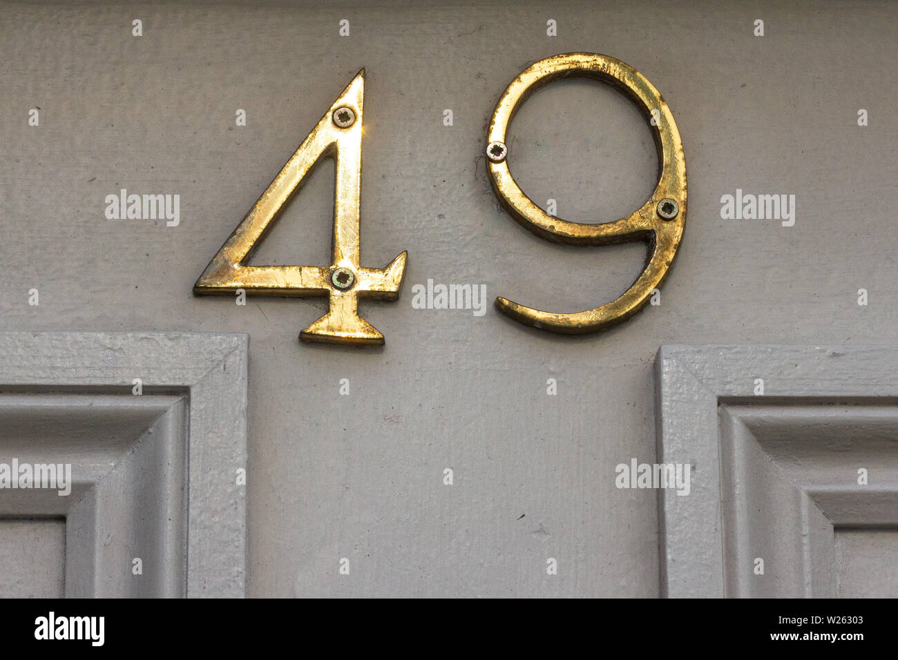 House number 49 with the forty-nine in bronze metal digits on a wooden ...