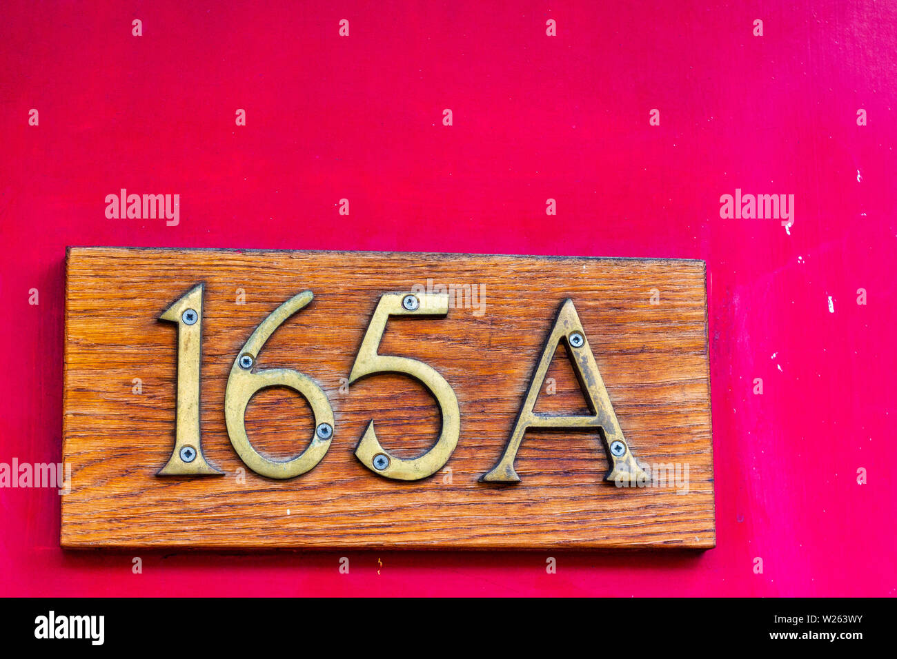 House number 165 with the in 165 metal digits on a wooden front door ...