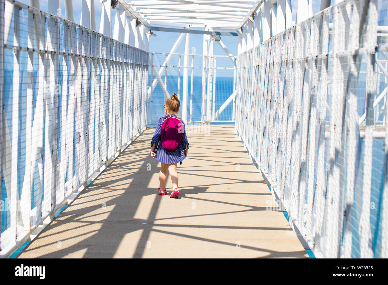 Little girl runs across the bridge Stock Photo - Alamy