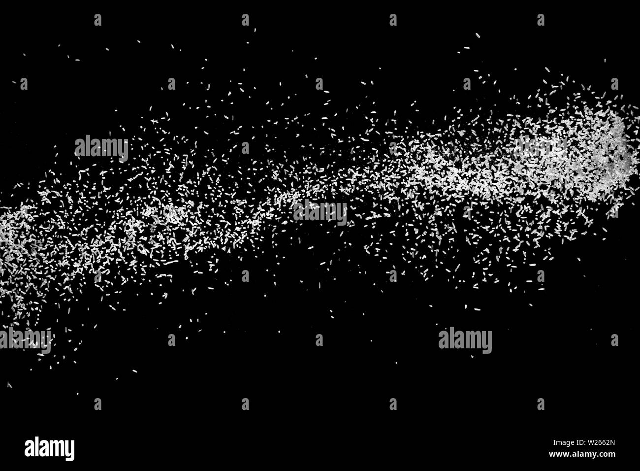 White rice grains splatter on black background Stock Photo - Alamy