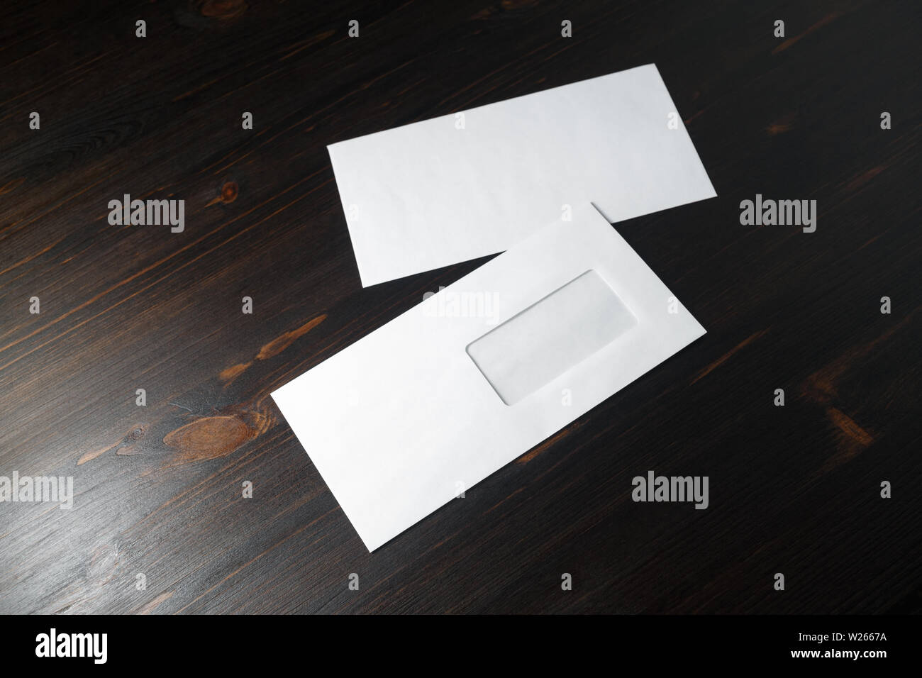Photo of two blank paper envelopes on wooden background. Mockup for ...