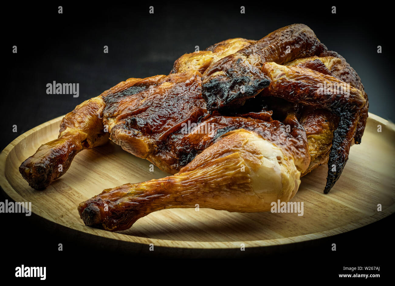 Roasted chicken on dish wood on black background Stock Photo - Alamy
