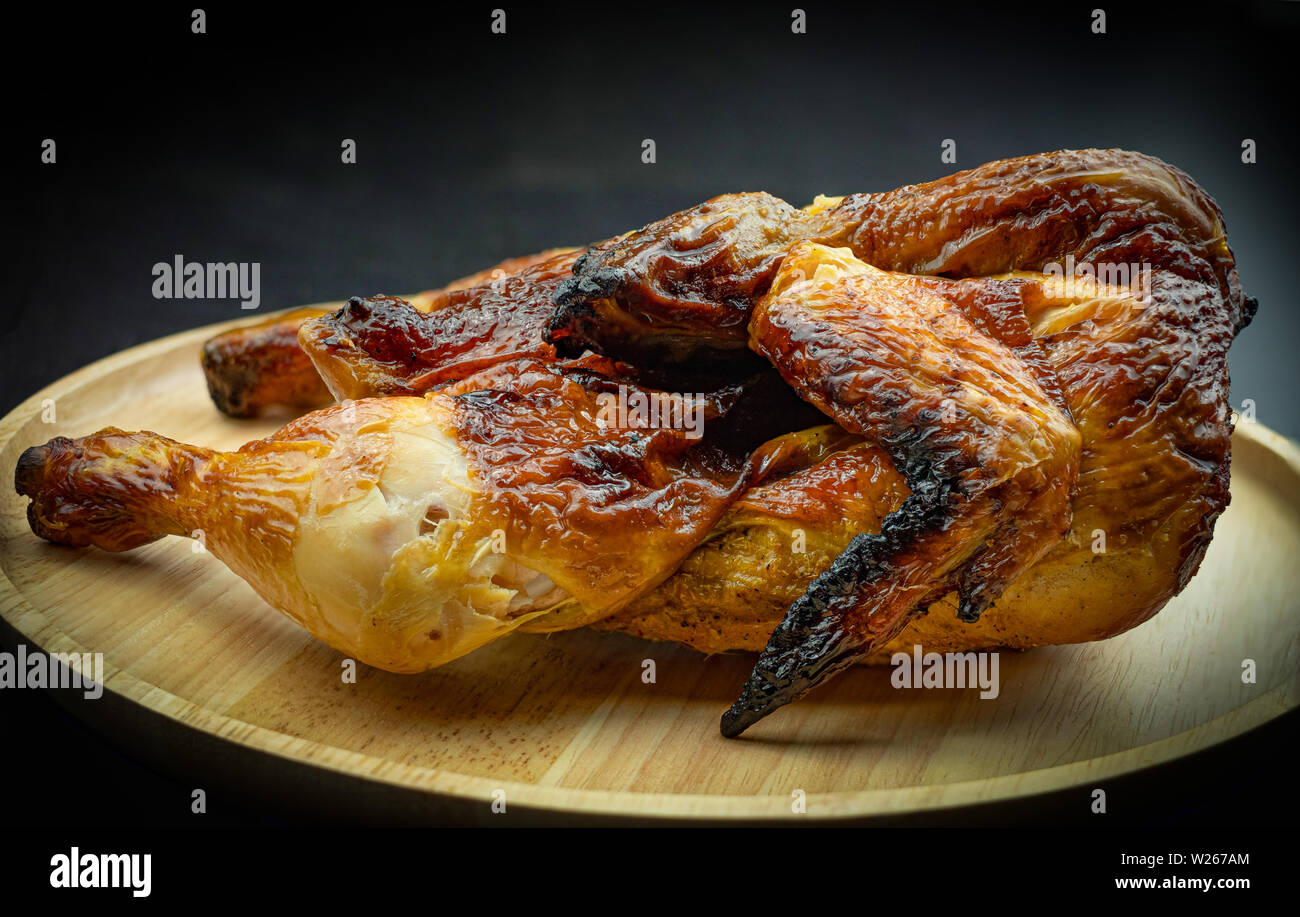 Roasted chicken on dish wood on black background Stock Photo - Alamy