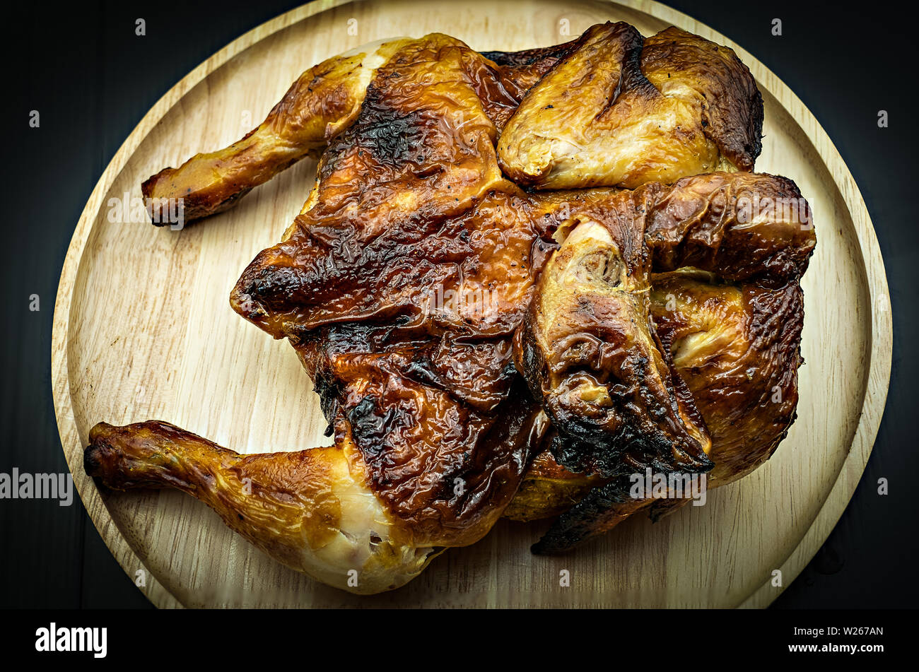 Roasted chicken on dish wood on black background Stock Photo - Alamy