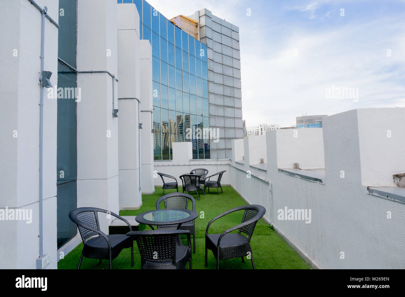 Outdoor seating space in a building with artificial grass and seats ...