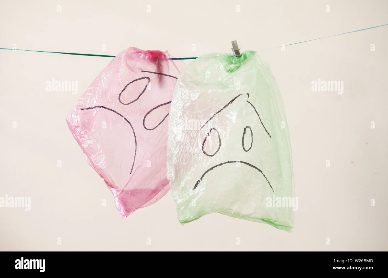 Plastic bags with sad emotions against white background. Ecology ...