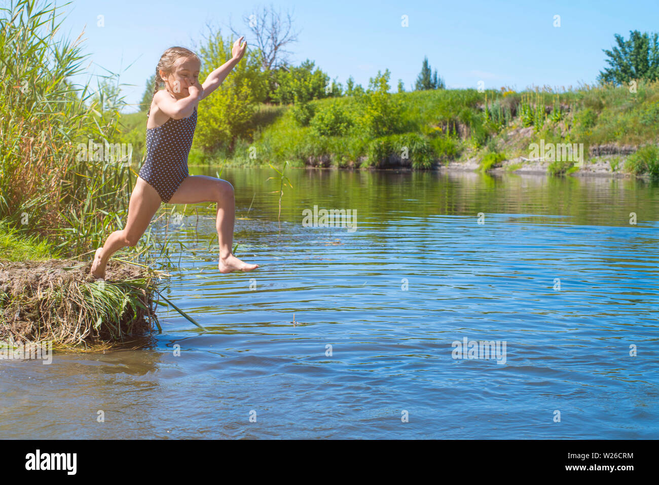 little girl running through the water with a splash . in her hands ...