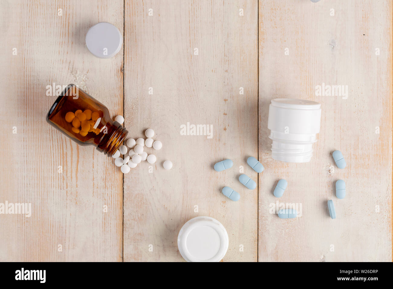 Glass and plastic bottles of medicine. Blue tablets and colored medical ...