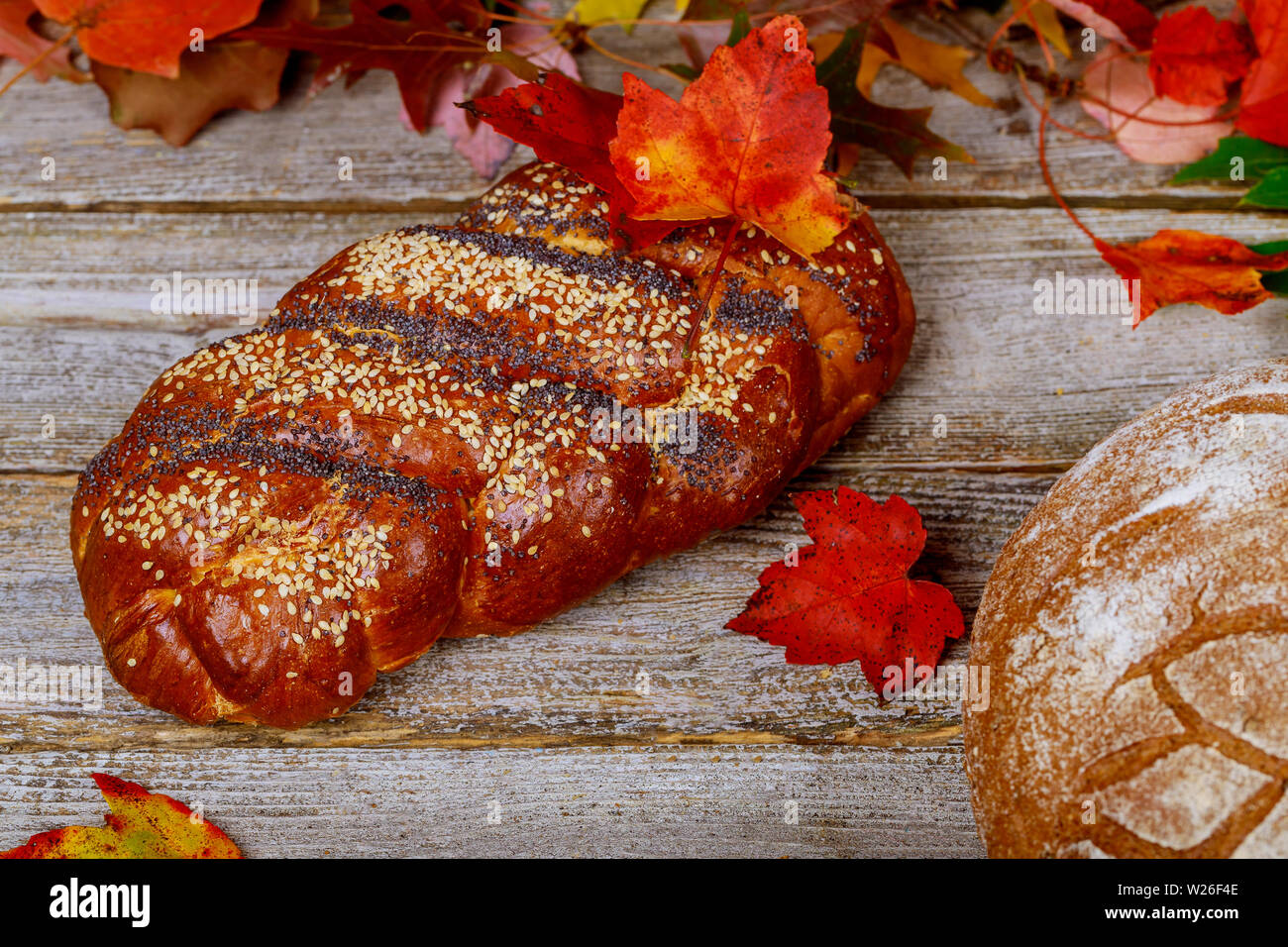 A loaf of bread among the yellow autumn leaves. Harvest time Stock ...