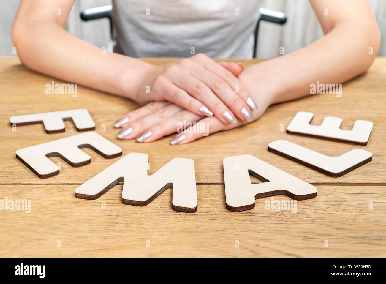word female laid out from wooden letters around female hands lying on ...