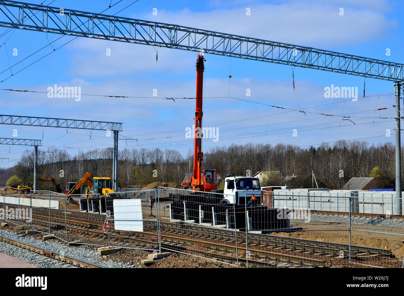 Crane and excavator work on the construction site on the railway ...