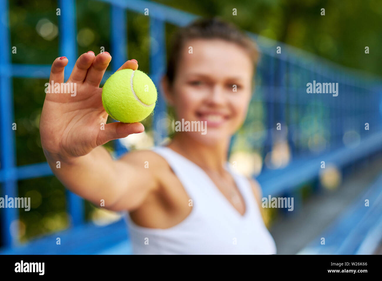 A tennis ball close-up in the hand of a pretty athlete Stock Photo - Alamy