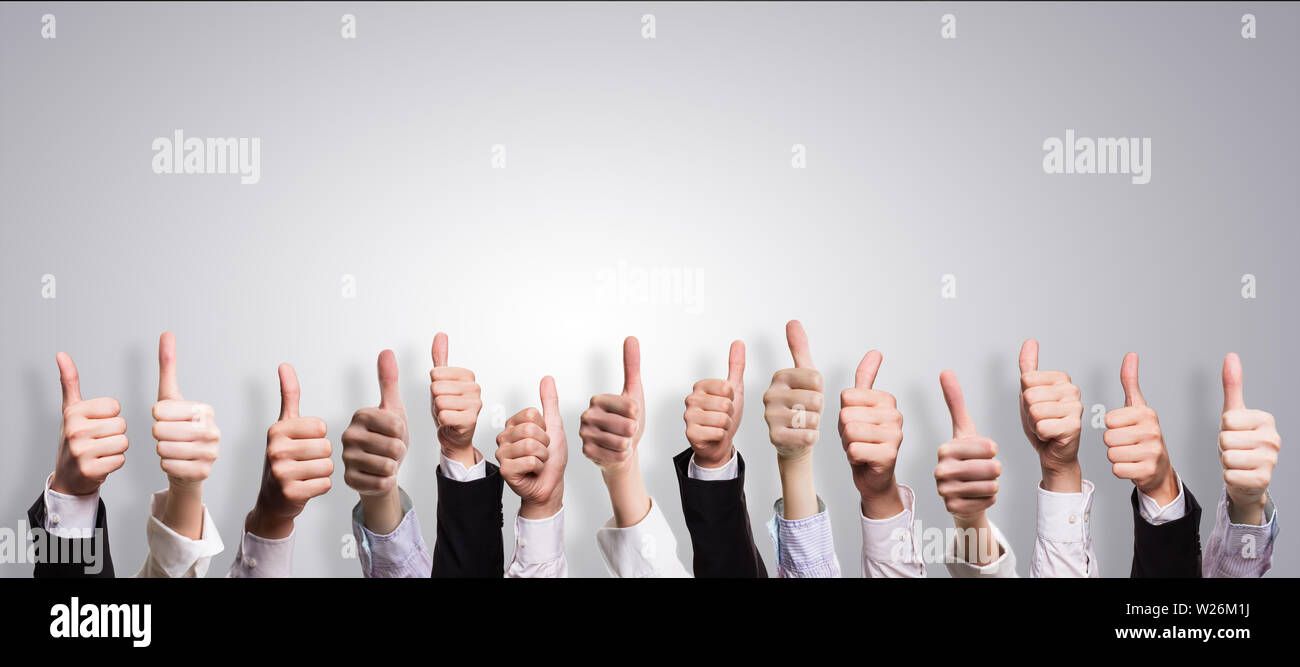 many thumbs up in front of a grey background Stock Photo - Alamy