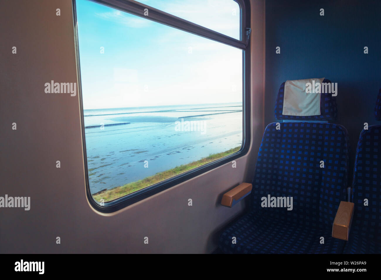 German train interior with an empty blue chair at the window with the ...