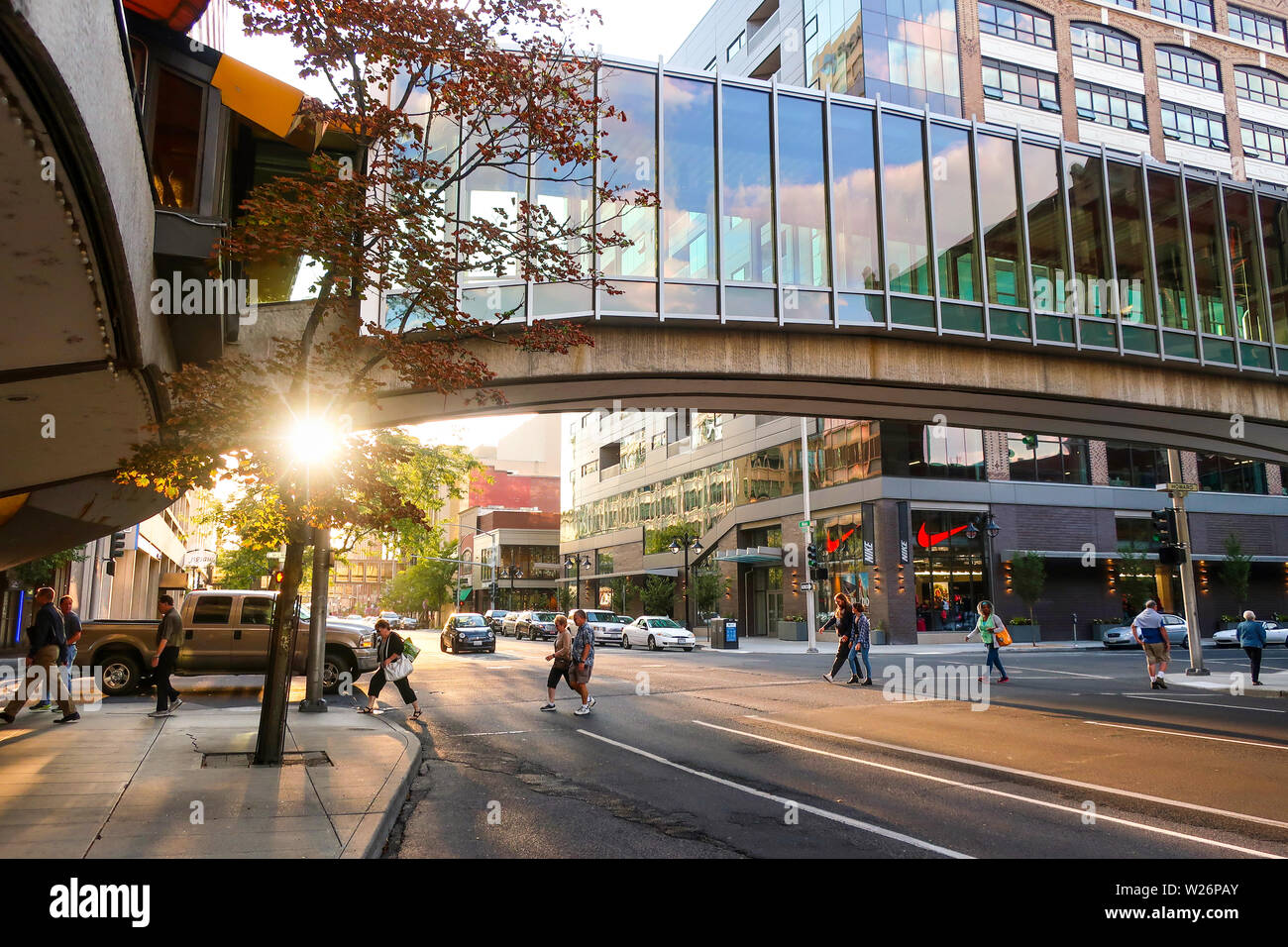 Pedestrians cross the street under the enclosed pedestrian bridge in ...