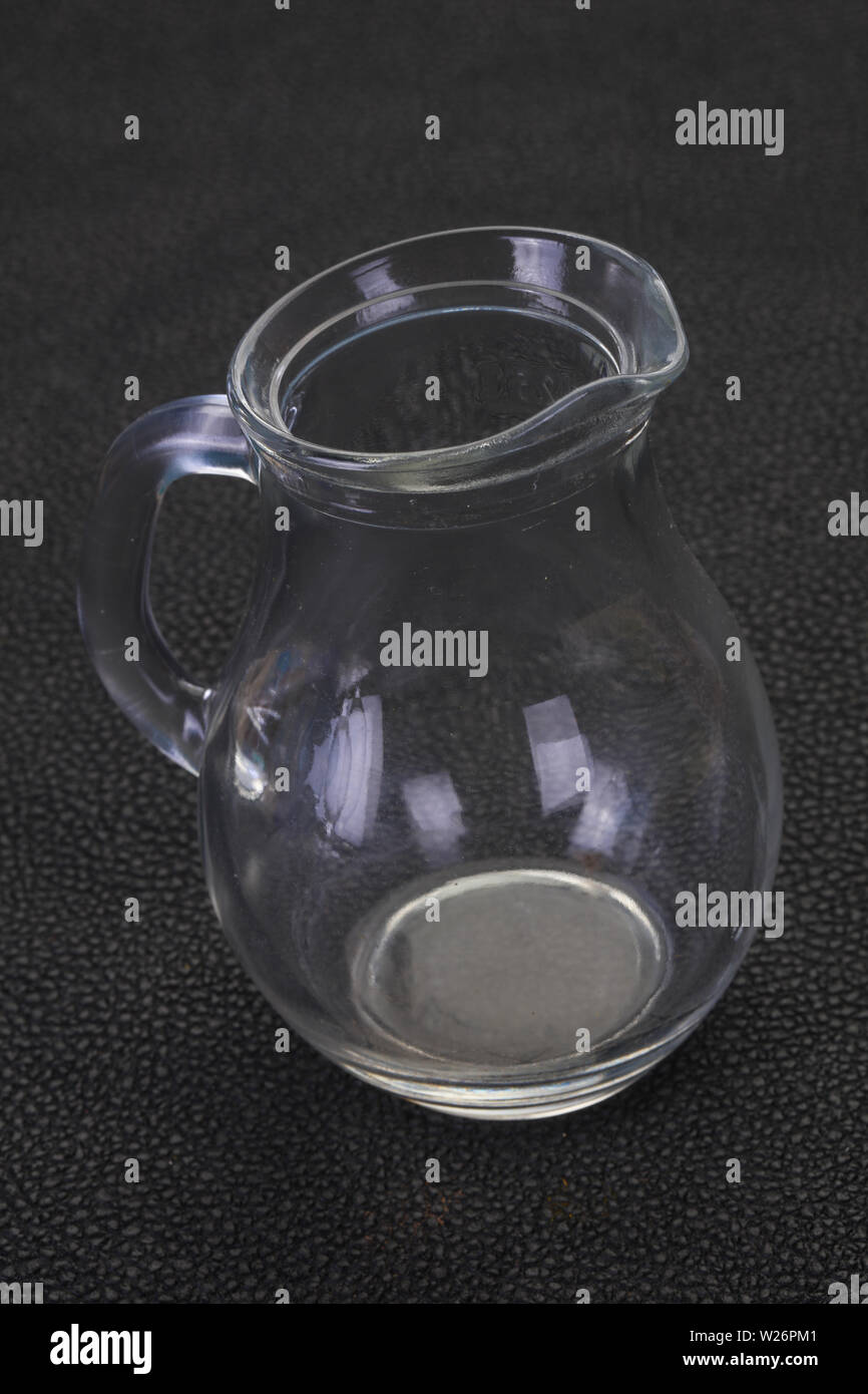 Empty glass jug over black background Stock Photo - Alamy