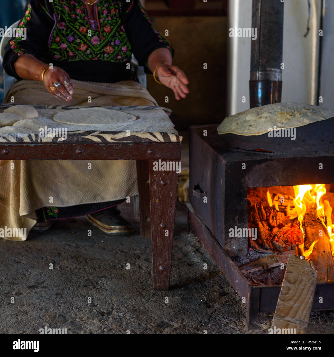 Old arab woman cooking traditional bedouin cuisine food - taboon bread ...