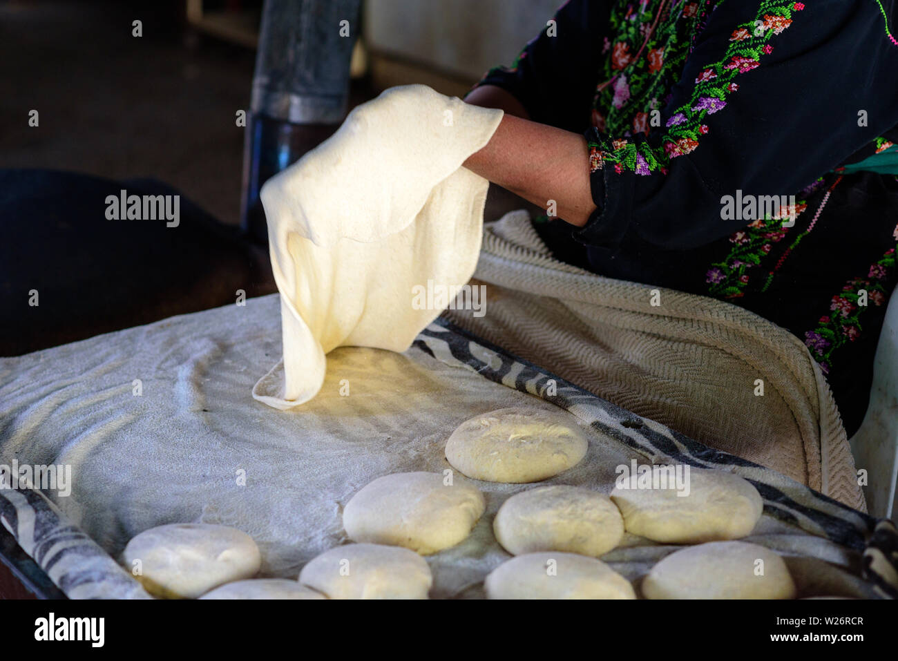 Close up Arabian old woman hand cooking flatbread or laffa or pita ...