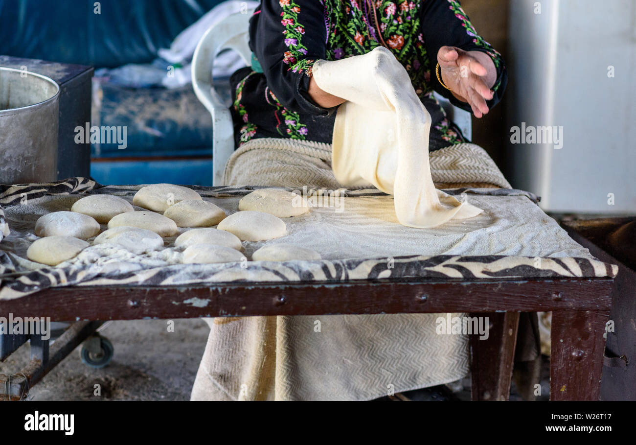 Close up of old Arab woman hands kneading fresh dough for Taboon bread ...