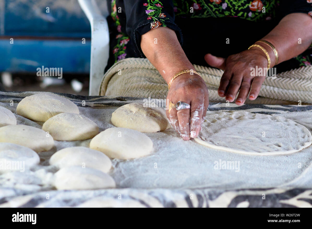 Close up of old Arab woman hands kneading fresh dough for Taboon bread ...
