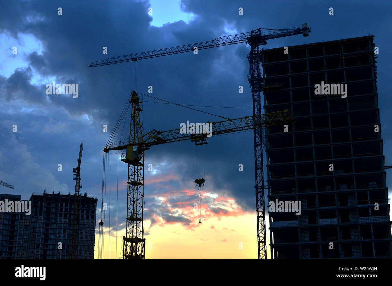 Tower cranes at construction site in the sunset sky - Image Stock Photo ...