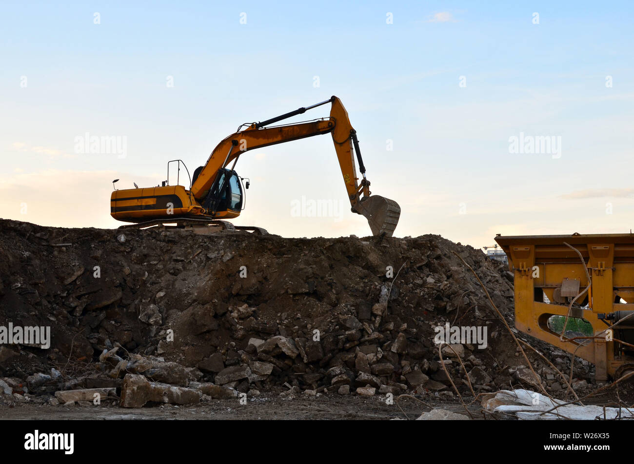 Heavy excavator working at construction site. Crushing and processing ...