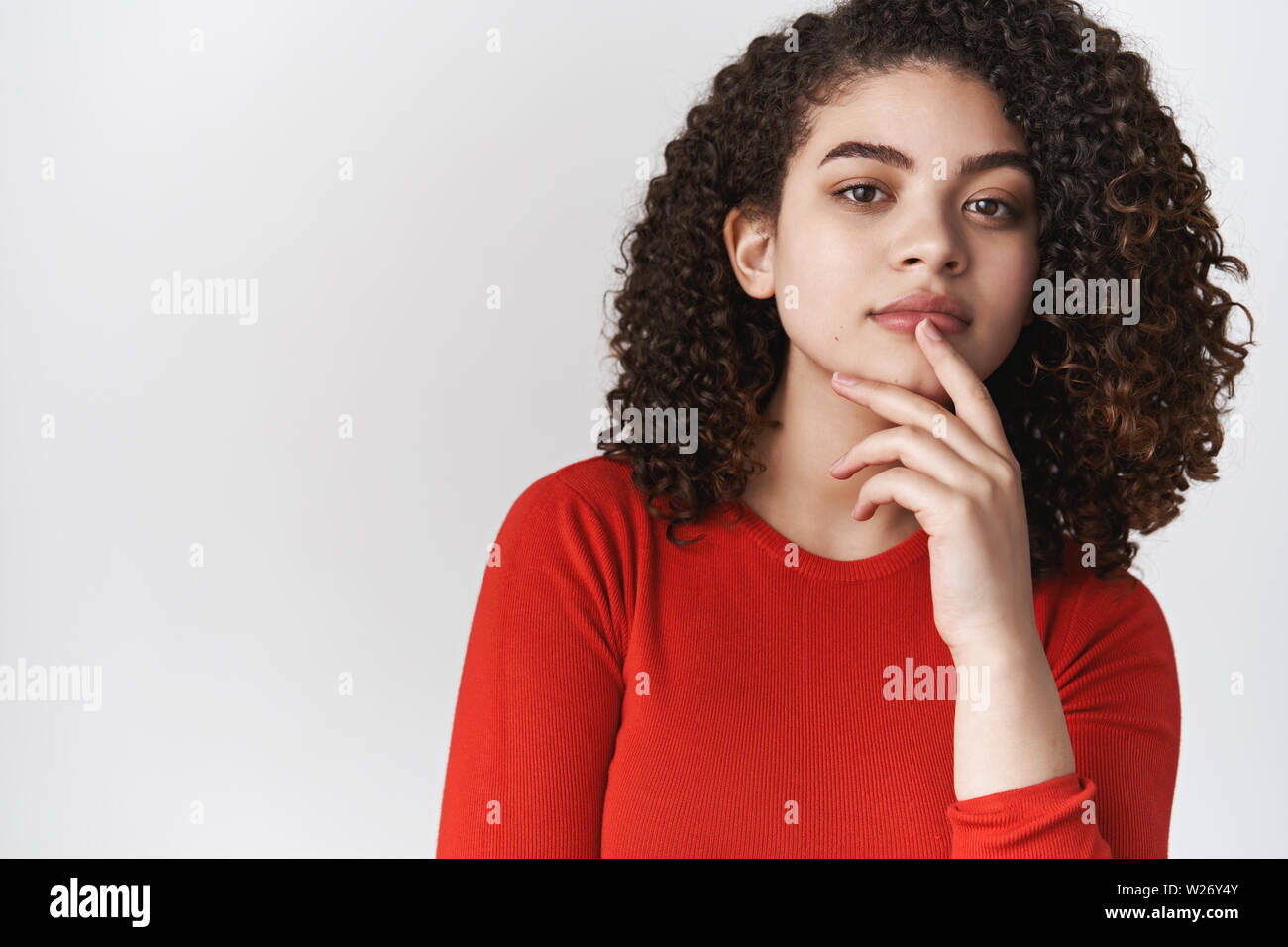 Close-up thoughtful hispanic young stylish pondering girl dark curly ...