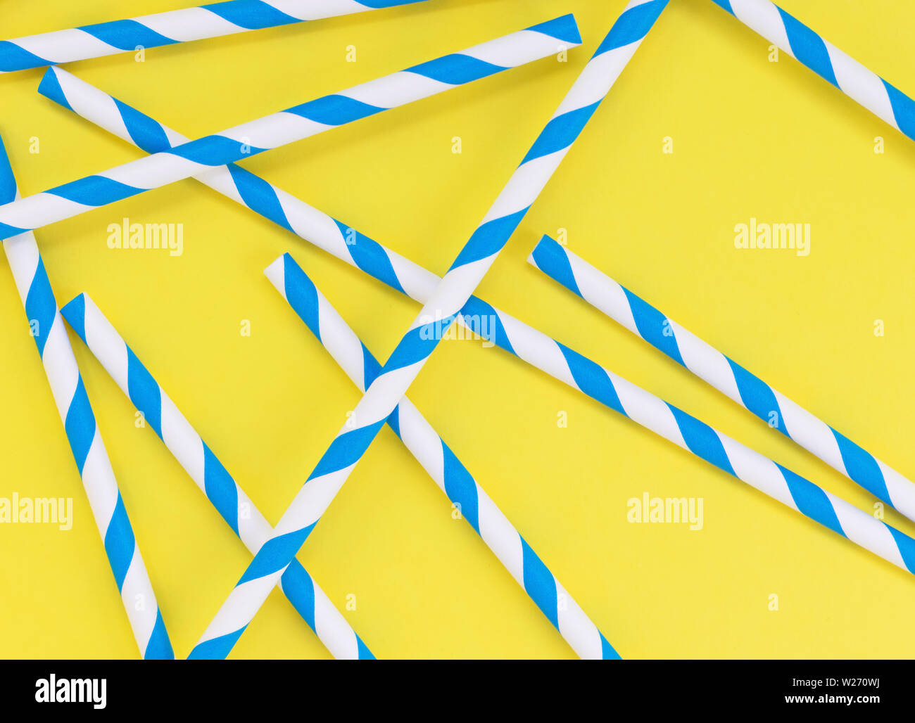 Blue striped paper straws scattered on a yellow background Stock Photo ...