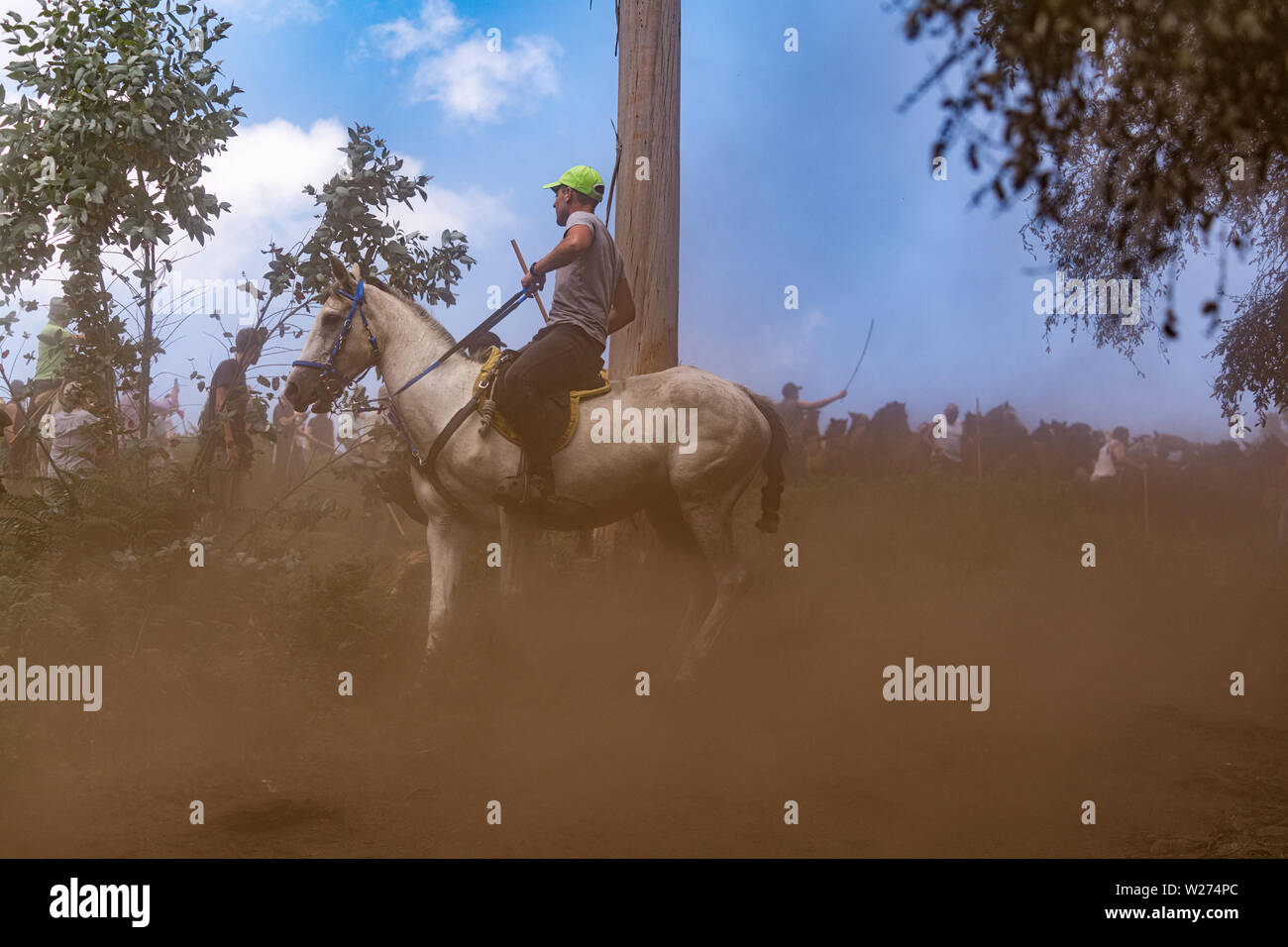 Mounted lcals rounding up wild horses in the mountains hi-res stock ...